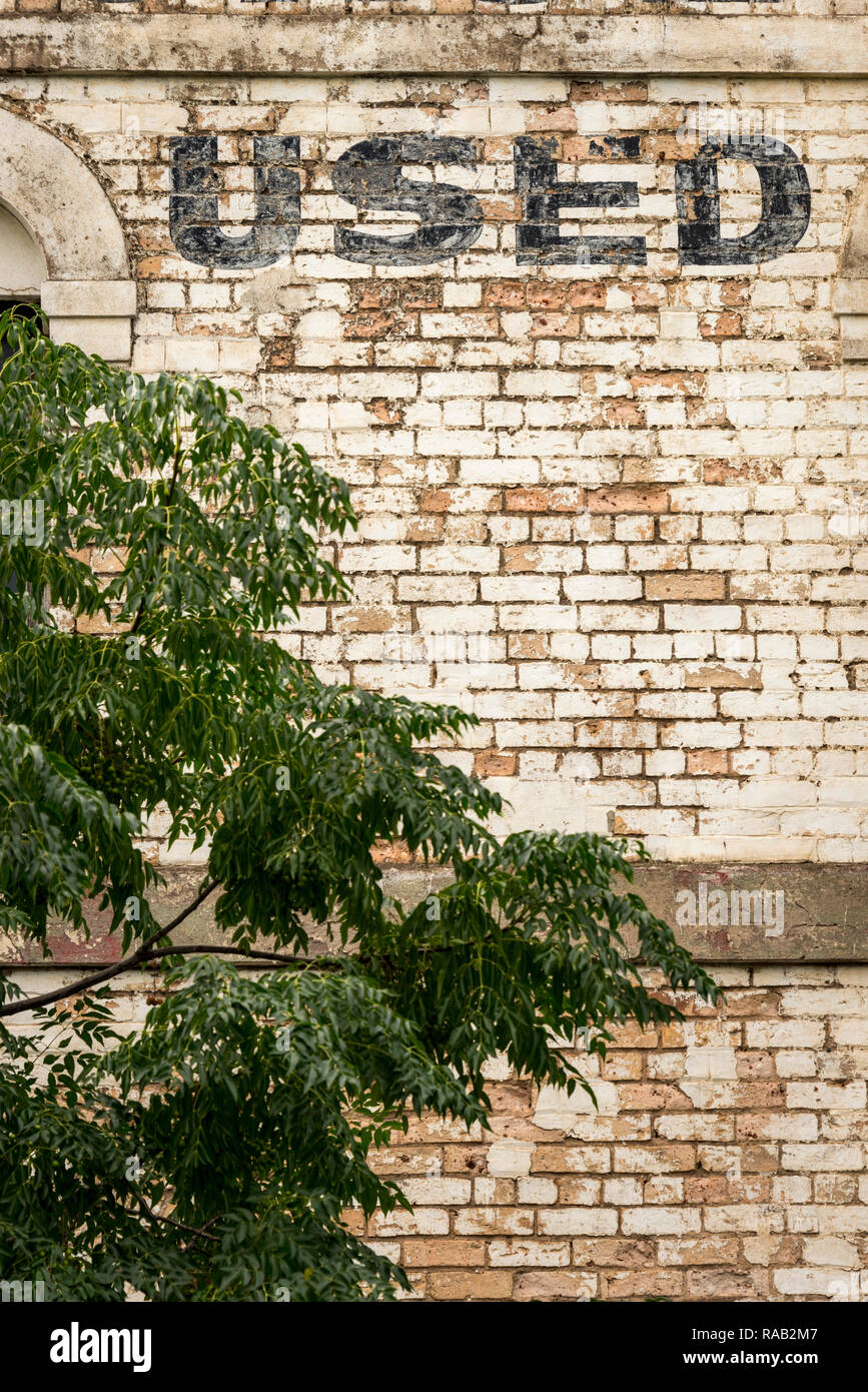 The word USED in weathered and faded text on a faded white painted ...