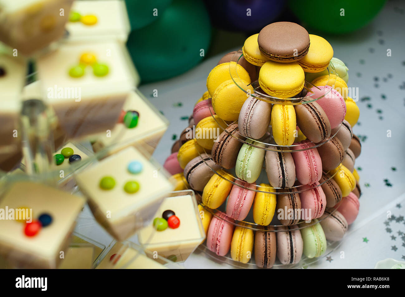 Mousse in glasses and colorful french macarons multilevel cake pyramid ...