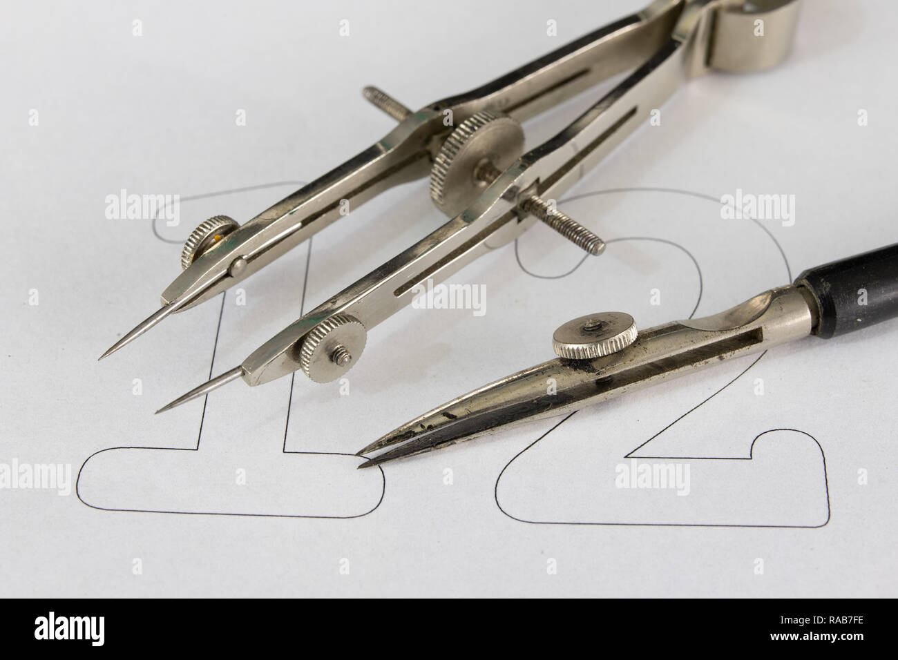 A companion for drawing circles on a white piece of paper. Drafting ...