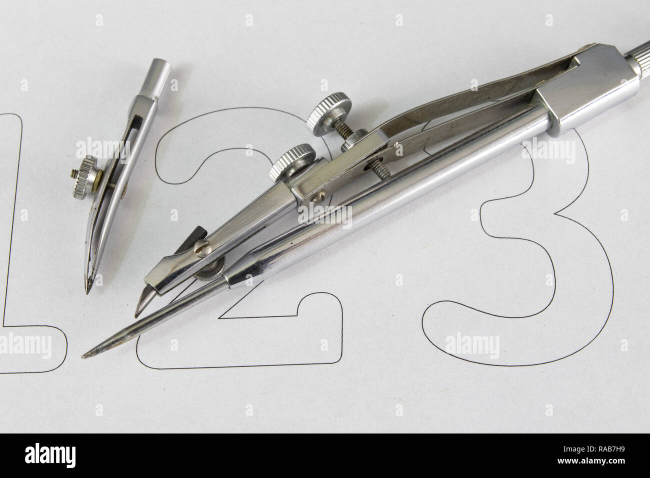 A companion for drawing circles on a white piece of paper. Drafting ...