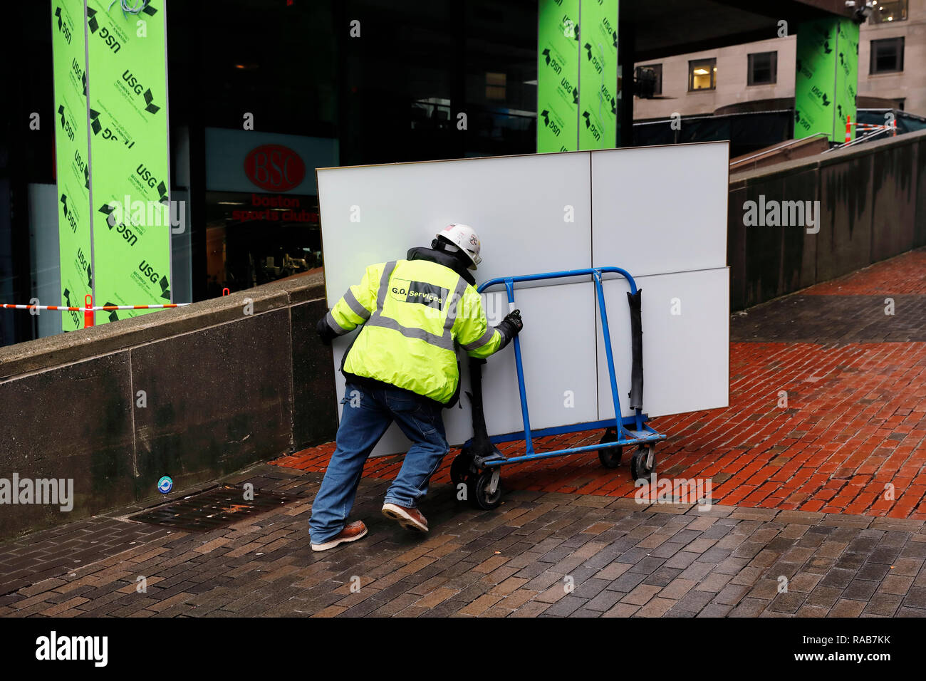 Construction worker pushing a cart up an incline, Boston, Massachusetts ...