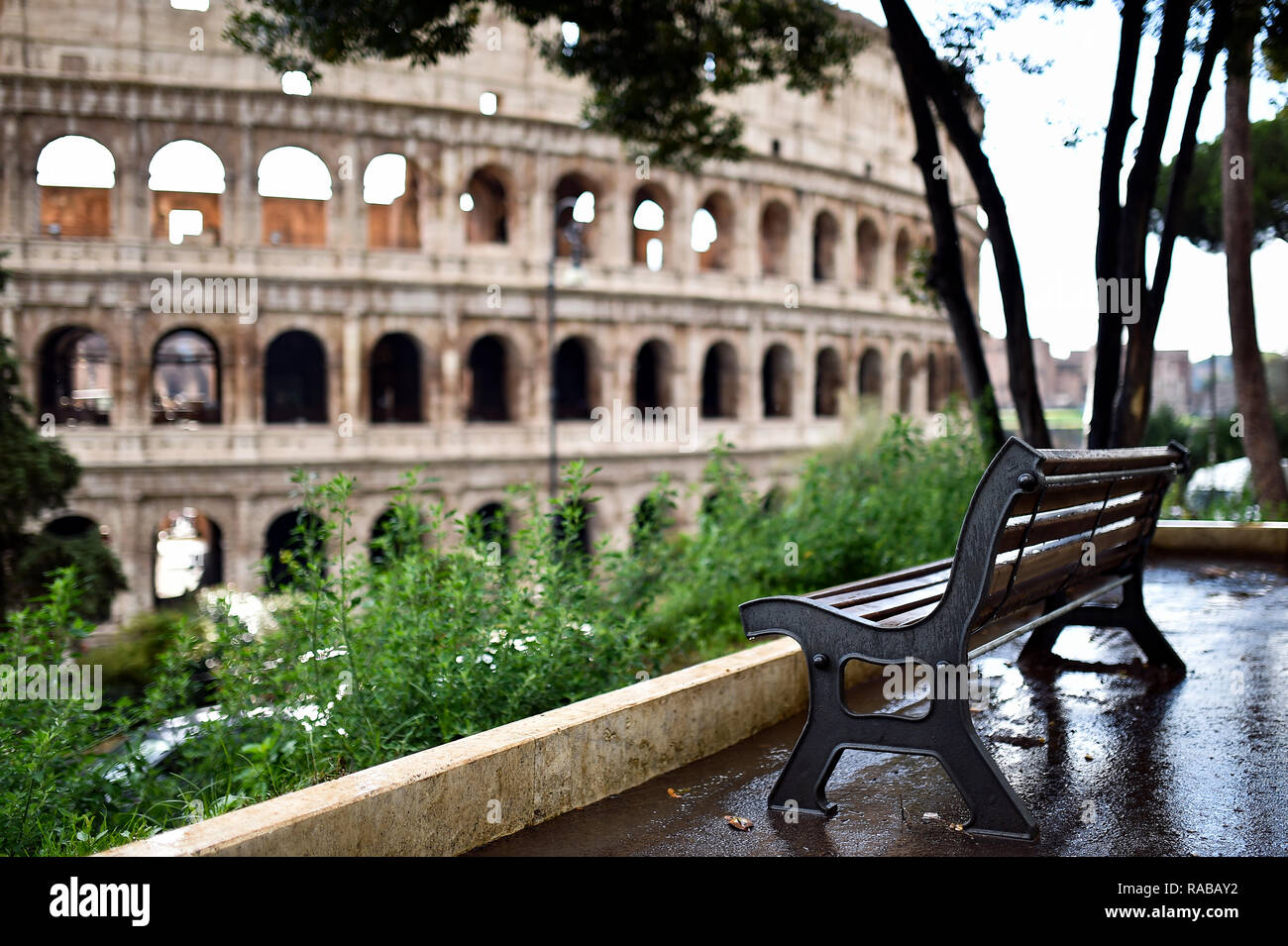 Spectacular view of the Coliseum with an empty bench in the foreground ...