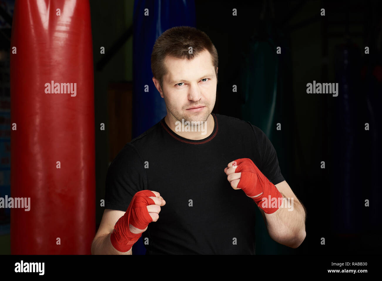 Portrait of strong caucasian man fighter on boxing bags background ...