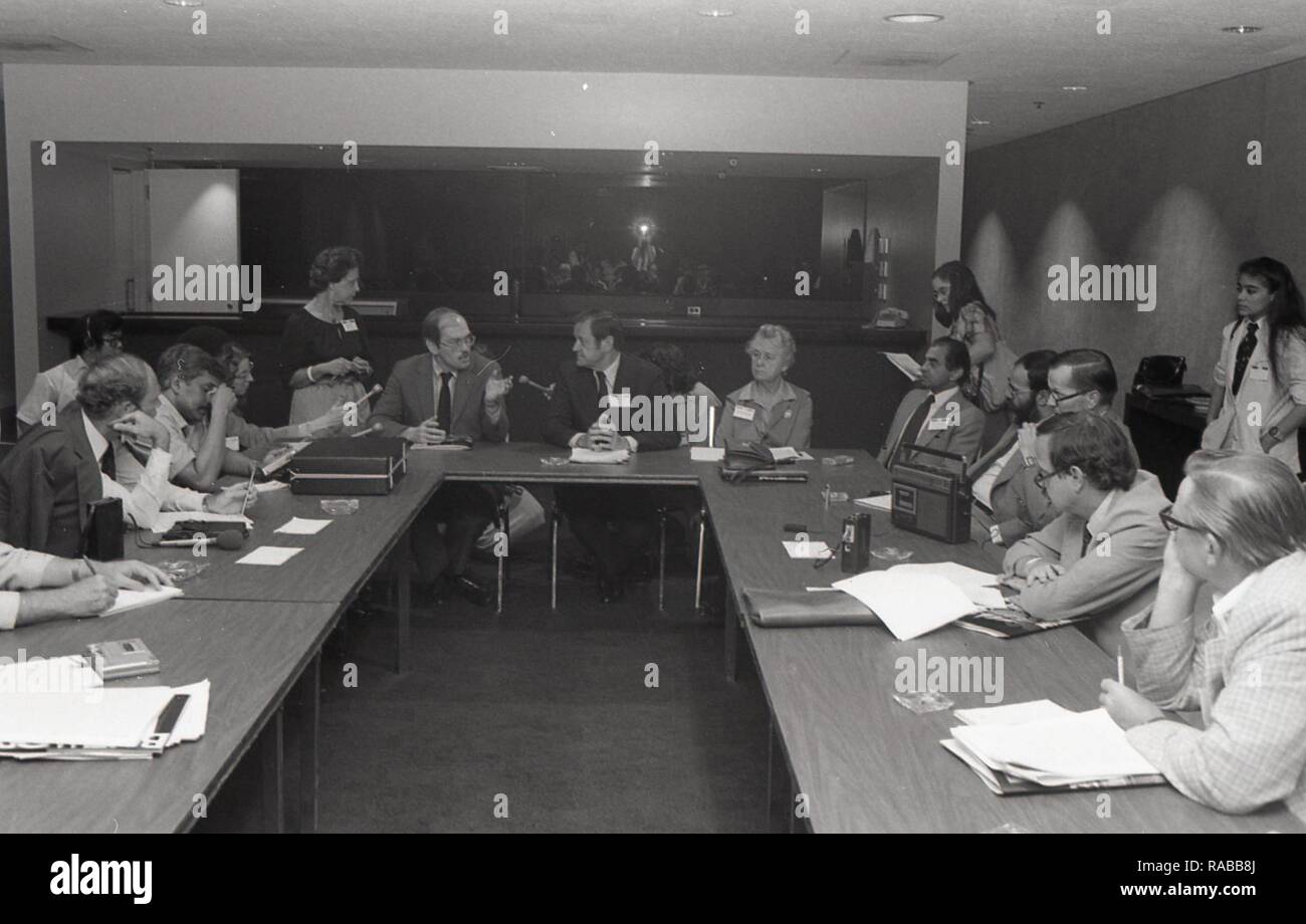 THIS PHOTO SHOWS A GROUP OF MEN AND WOMEN SITTING AROUND THE TABLE ...