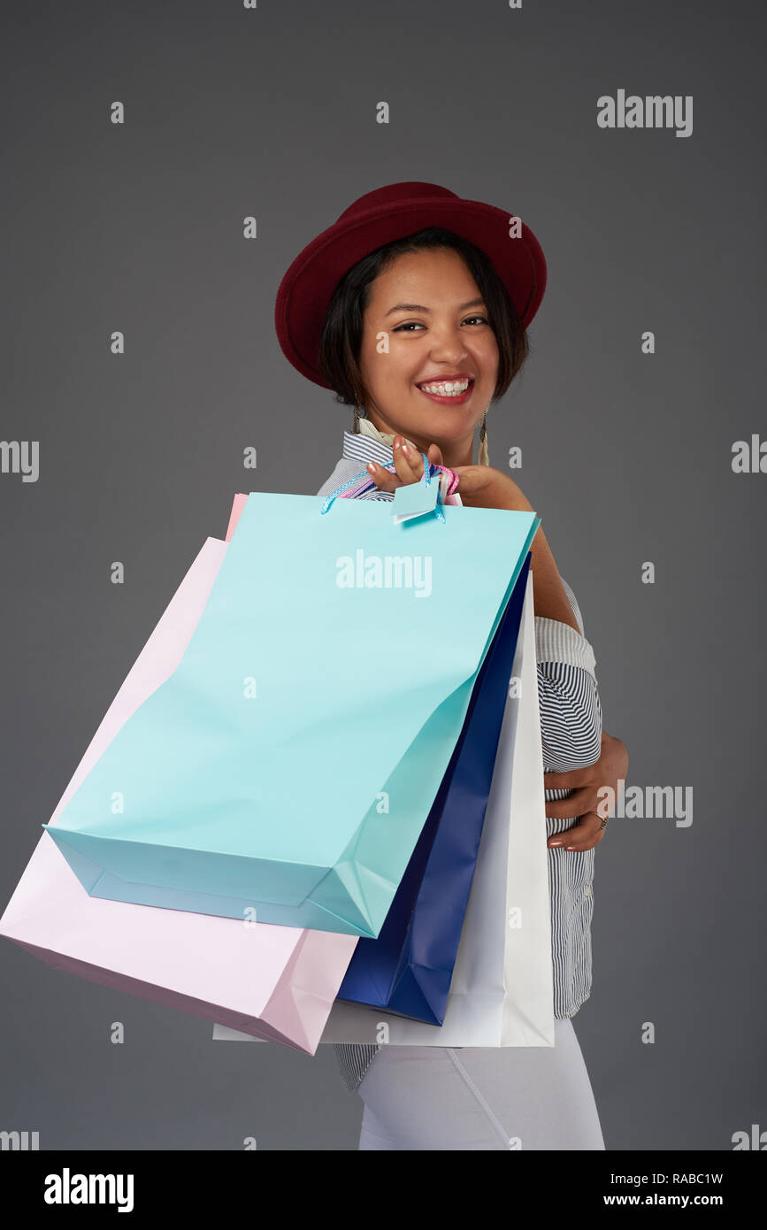 Happy smiling woman shopaholic with colorful bags on studio background ...