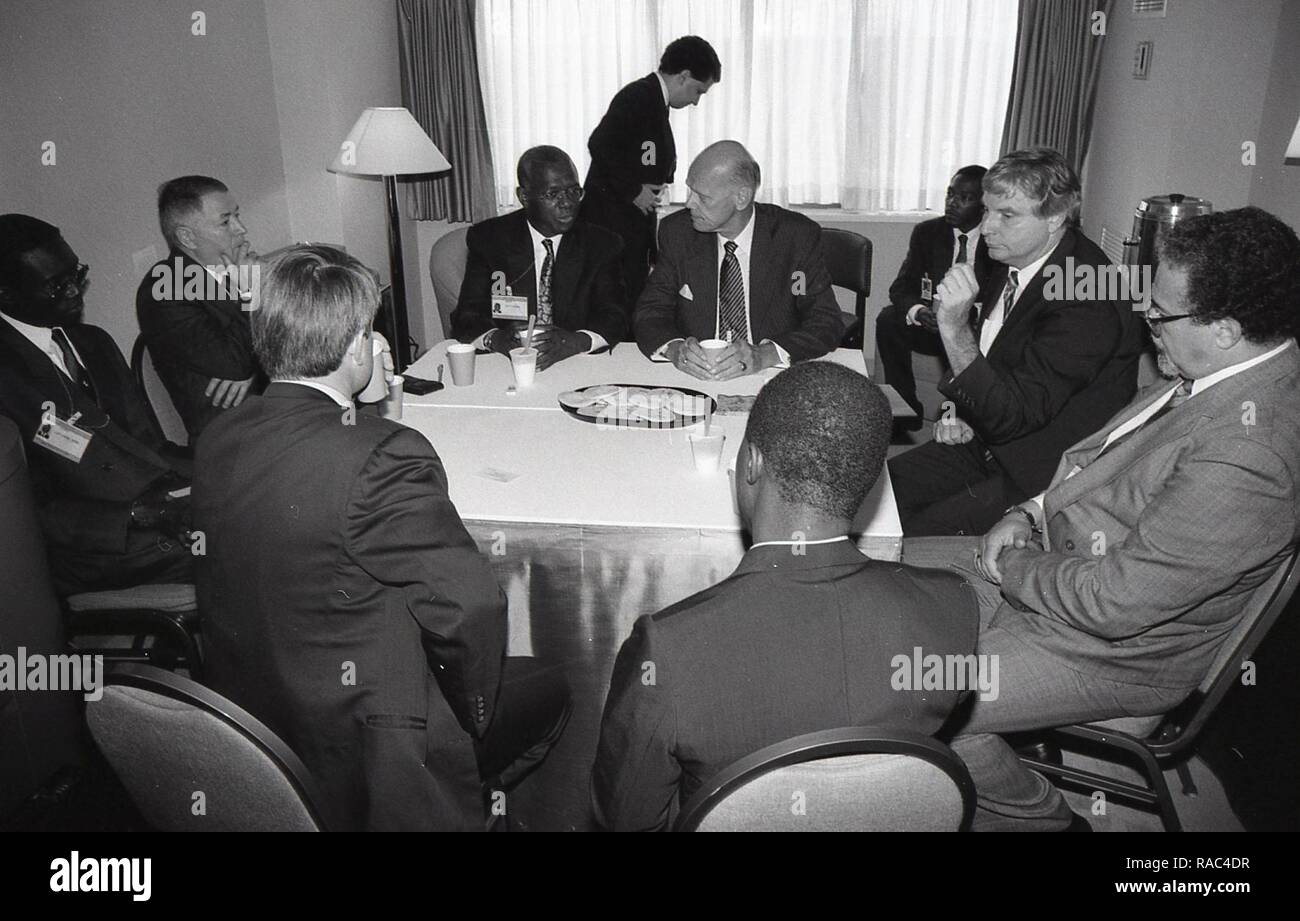 GROUP OF MEN SITTING AROUND THE TABLE HAVING A MEETING Stock Photo - Alamy