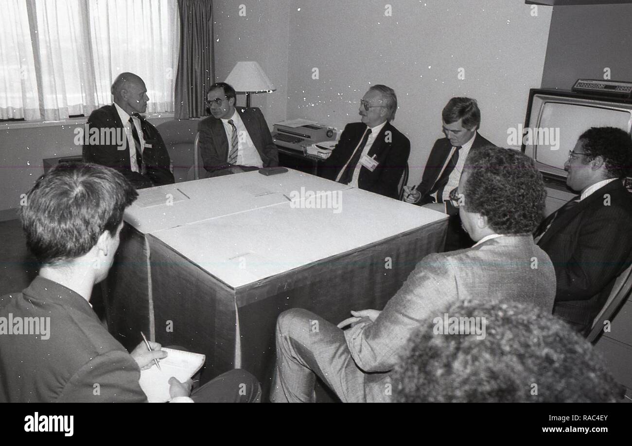 GROUP OF MEN SITTING AROUND THE TABLE HAVING A MEETING Stock Photo - Alamy