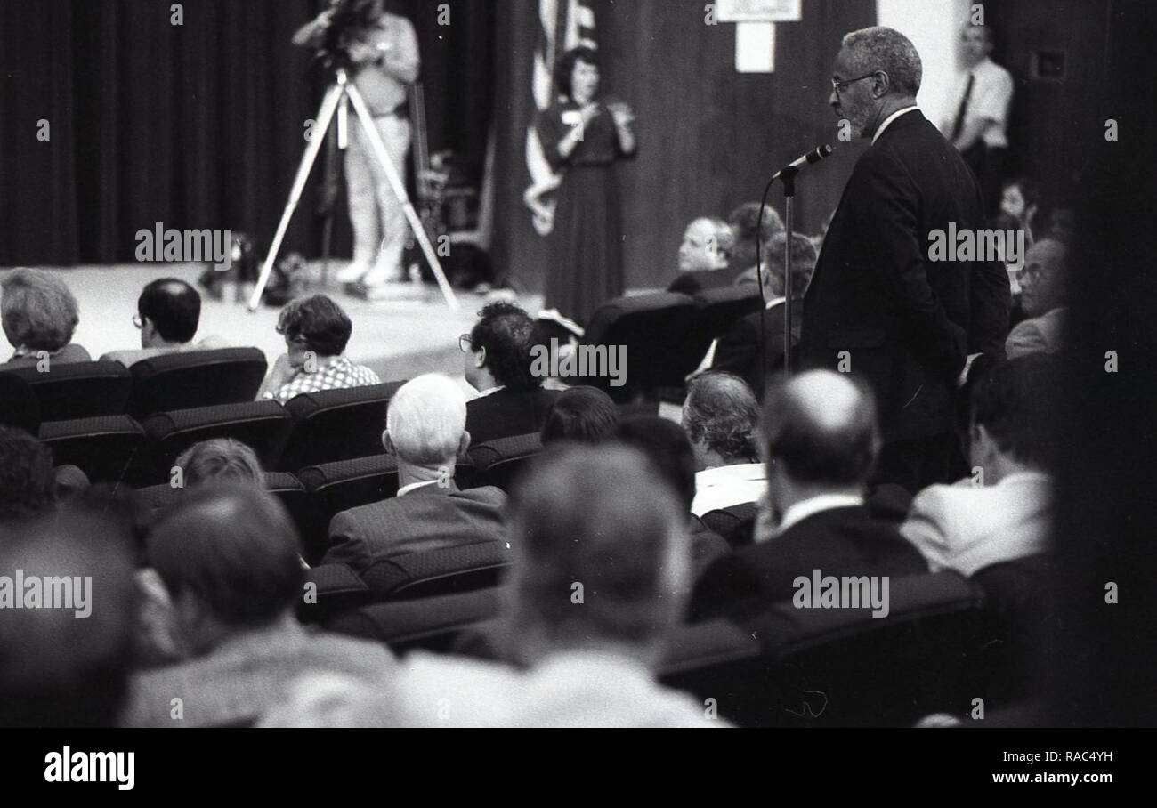 MAN STANDING TALKING TO A GROUP OF MEN AND WOMAN Stock Photo - Alamy