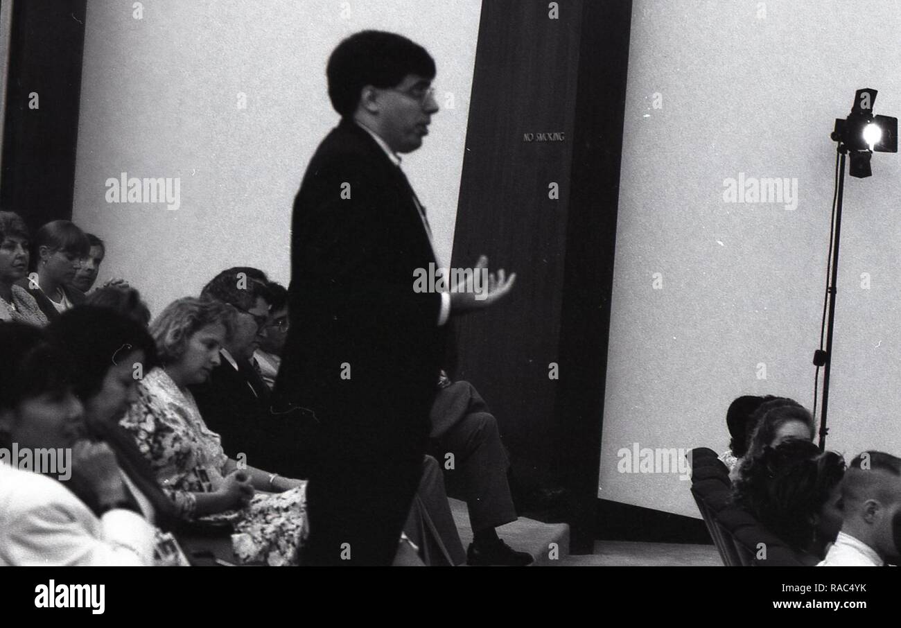 MAN STANDING TALKING TO A GROUP OF MEN AND WOMAN Stock Photo - Alamy