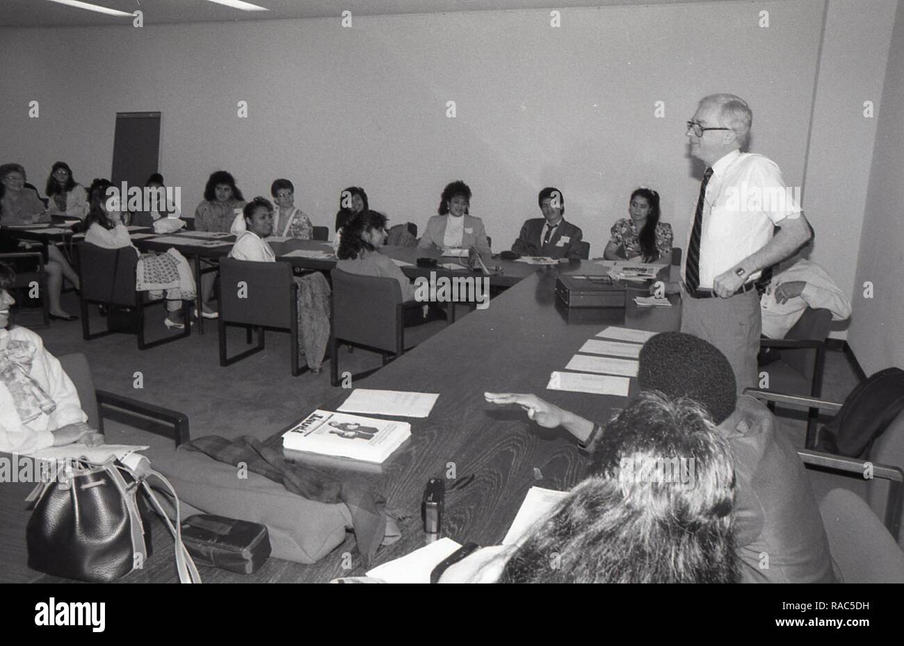 THIS IS SHOWING A MAN STANDING IN THE CLASSROOM SETTING HAVING A ...