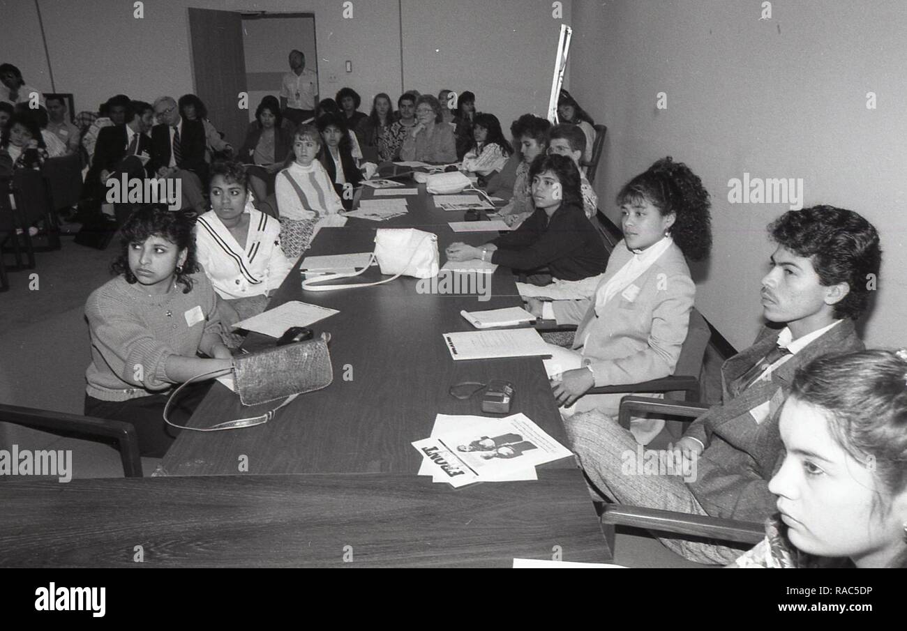 THIS PHOTO IS SHOWING A GROUP OF MEN AND WOMEN HAVING A MEETING OR ...