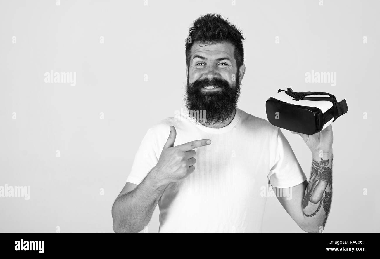 Man with beard and mustache holds VR glasses, white background. Guy ...