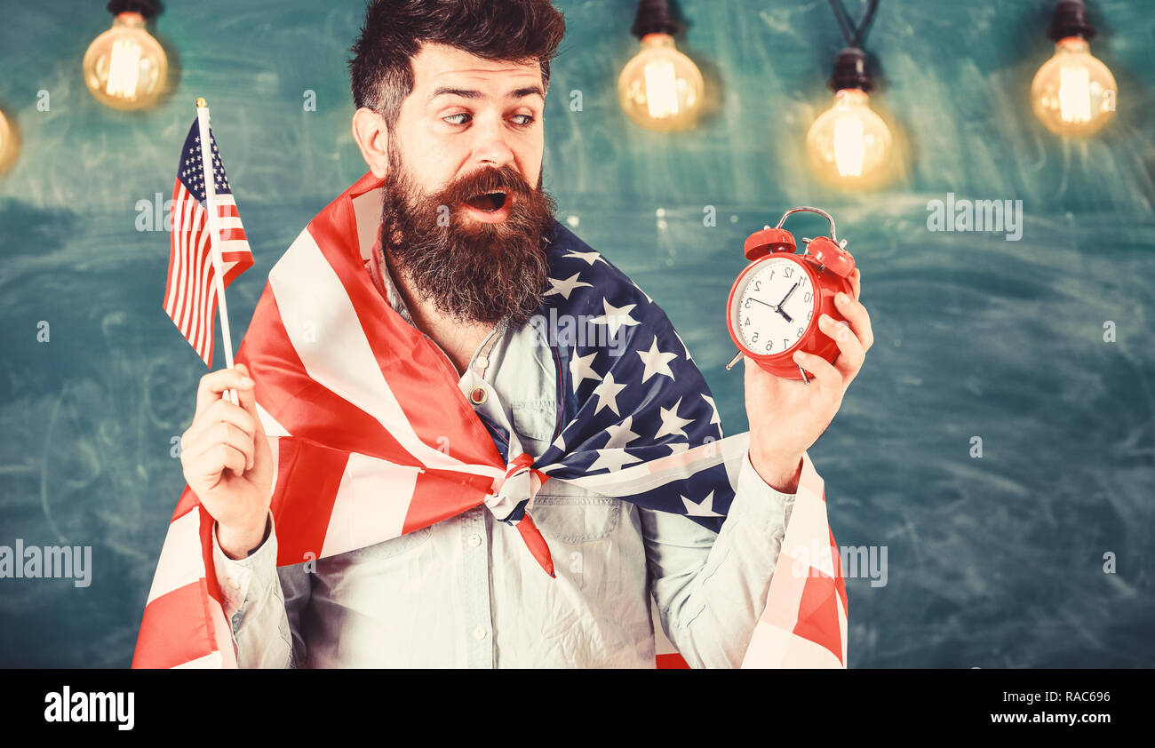 Man with beard on surprised face holds flag of USA and clock ...
