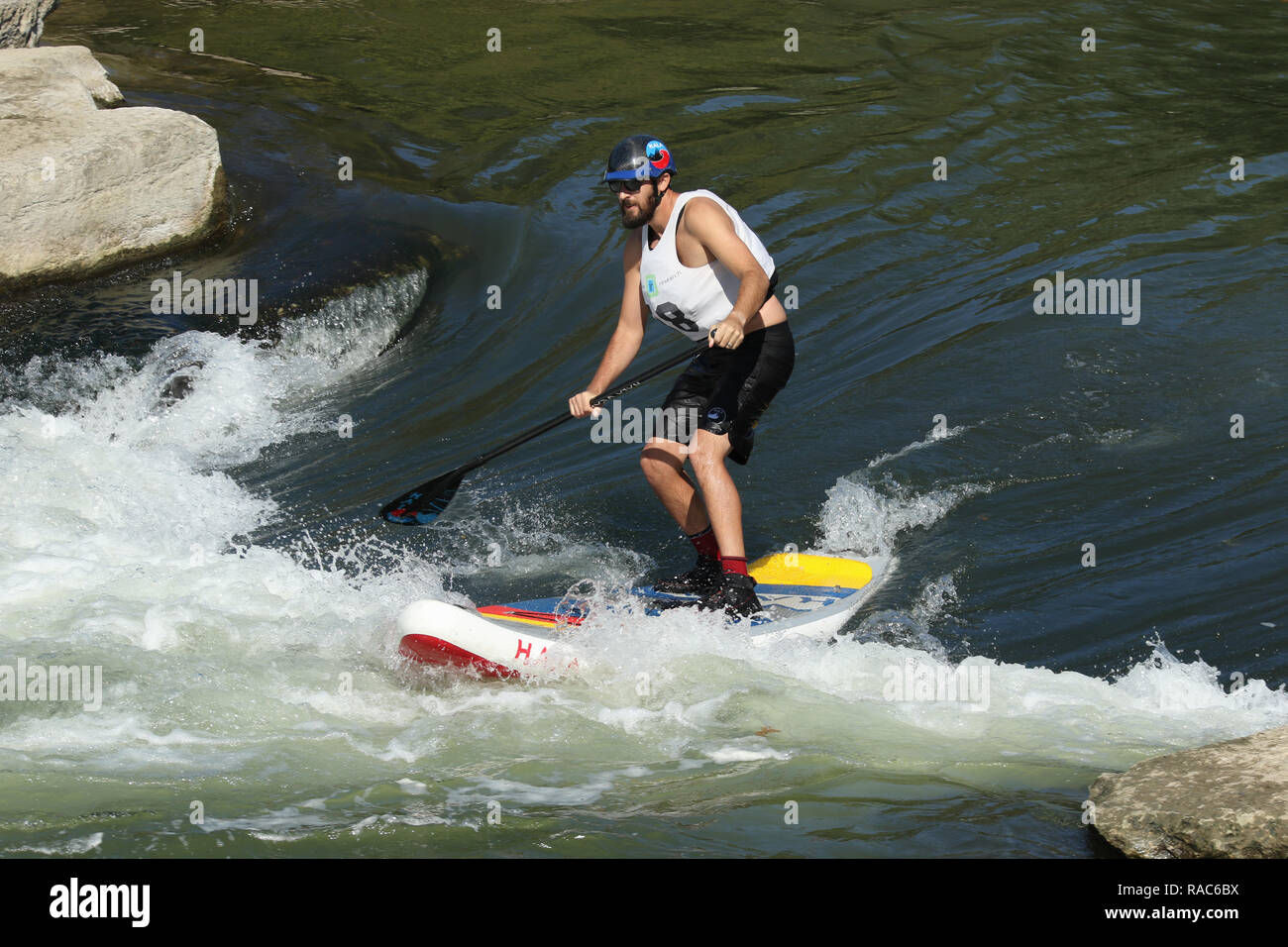 Standup Paddleboarder rides through a water trough. At the Whitewater ...