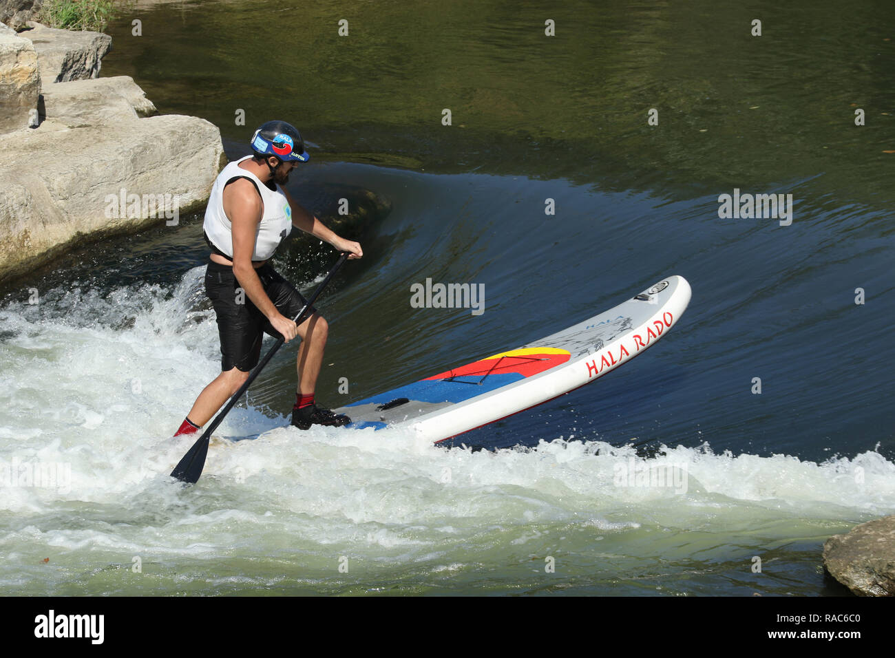 Standup Paddleboarder rides in a water trough. At the Whitewater ...