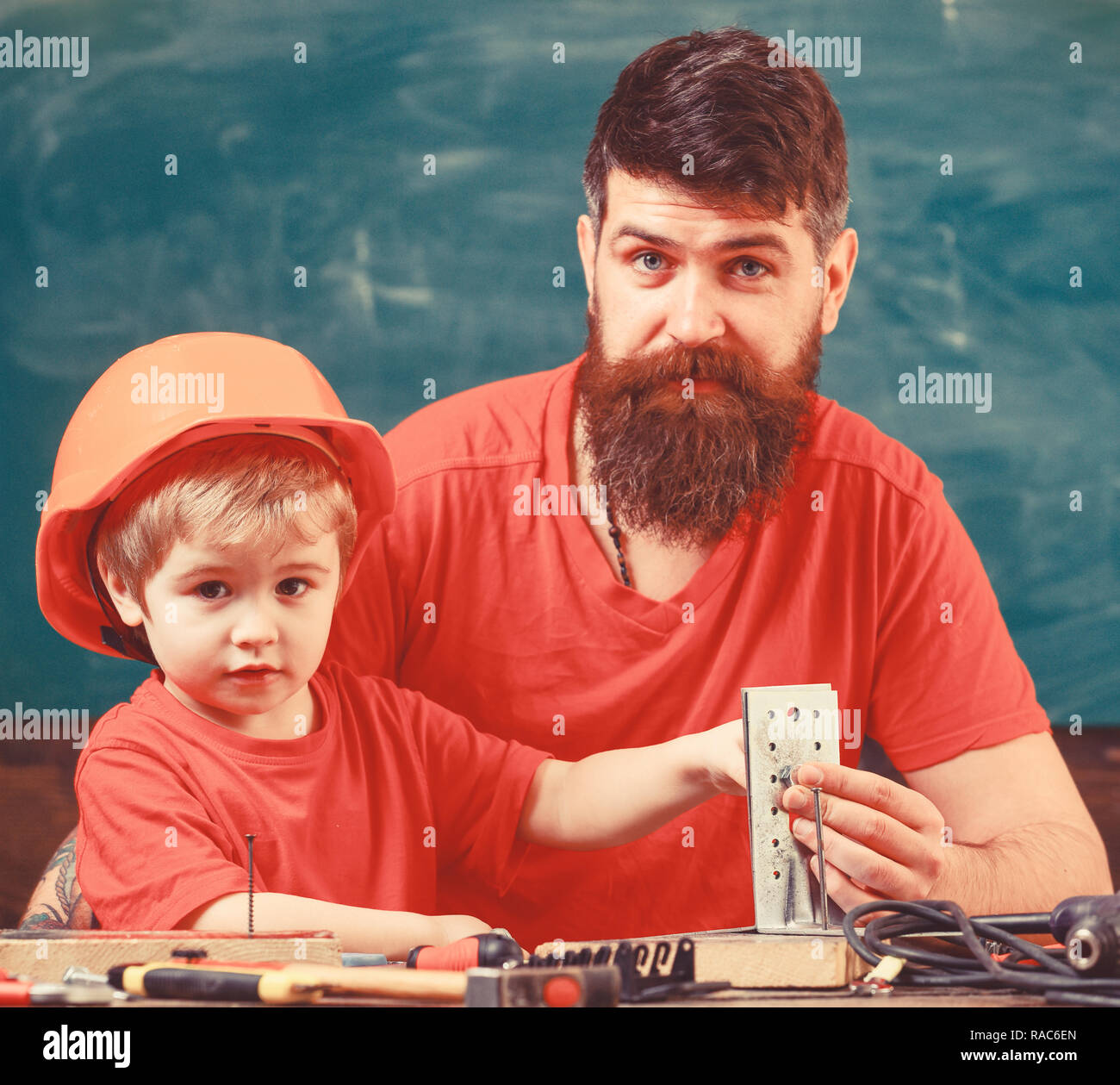 Little assistant concept. Father with beard teaching little son to use ...