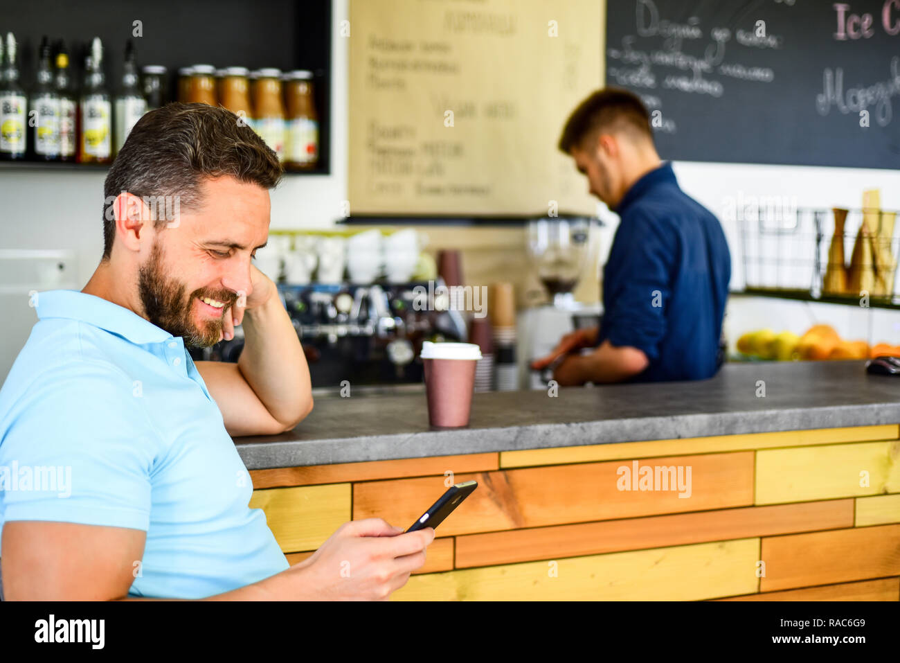 Man mobile reading message cafe barista background. Drink coffee while ...