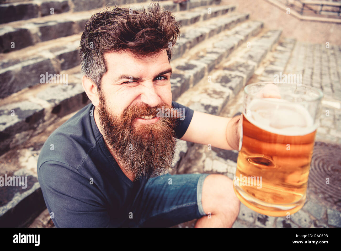 Celebration concept. Man with beard and mustache holds glass with beer ...