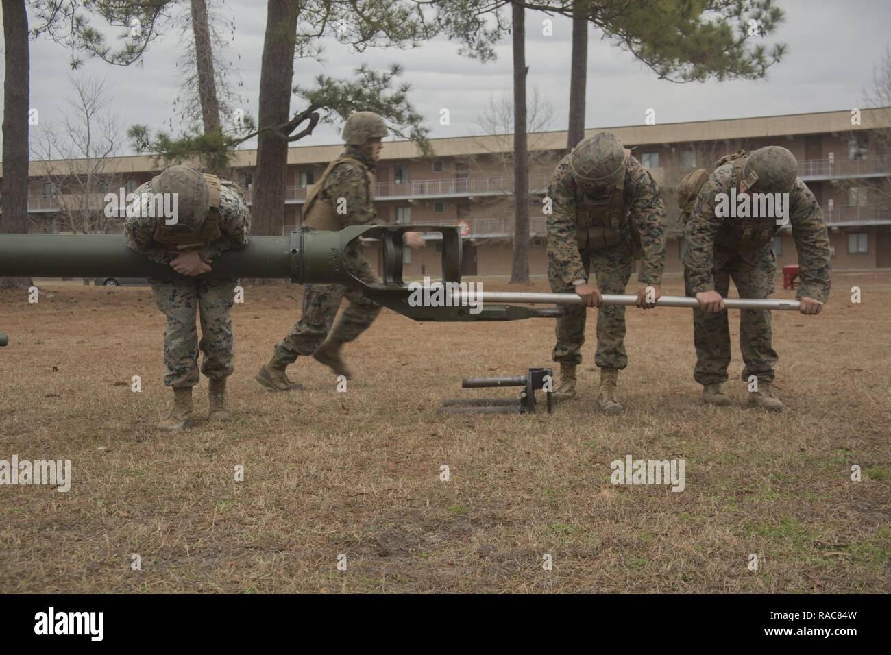 Marines with the Artillery Training School hold down the barrel of an ...