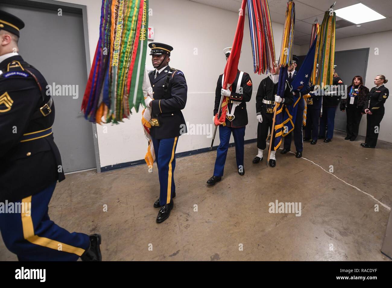 Members of the U.S. Military Joint Services Color Guard walk toward the ...