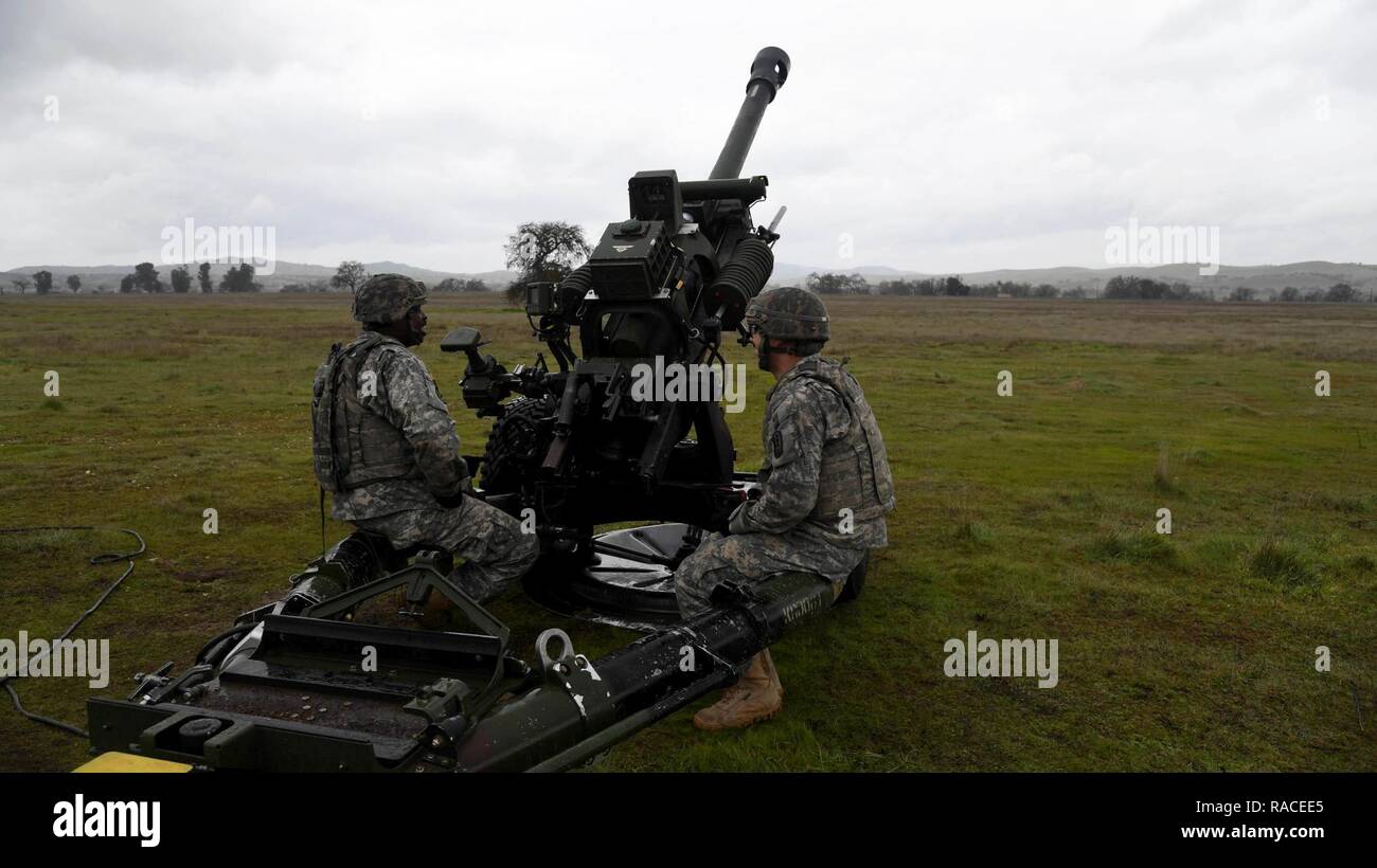 Army Soldiers assigned to Alpha and Bravo Battery, 1-143rd Field Artillery, wait for a fire ...