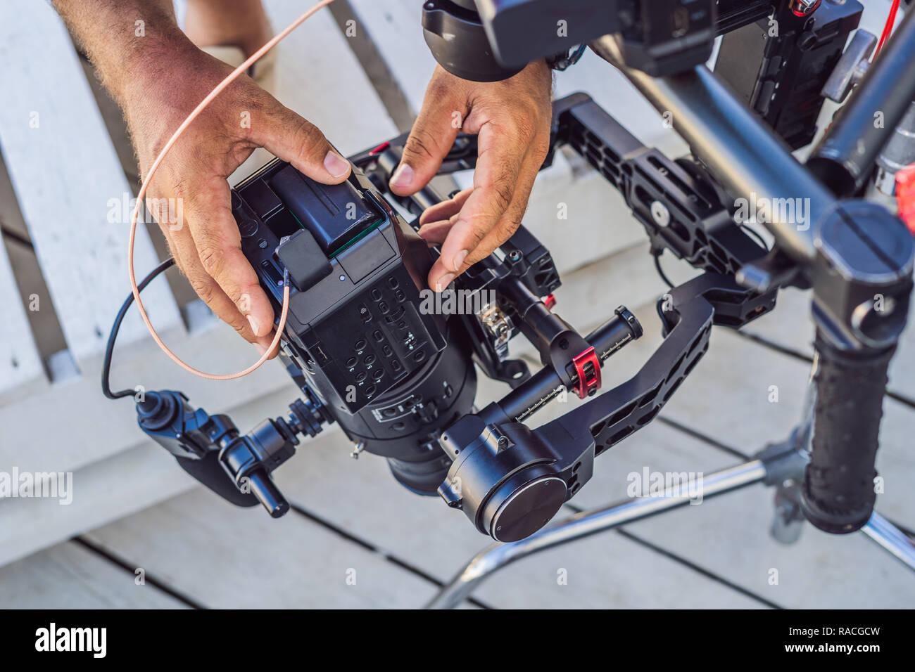 Steadicam operator and his assistant prepare camera and 3-axis ...