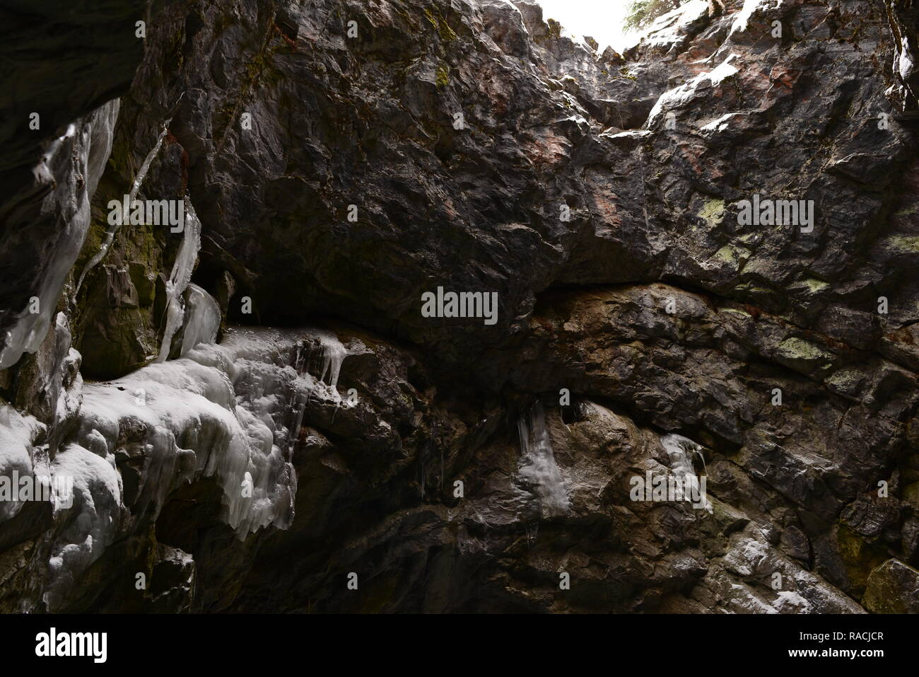 Snow and icy stone wall of a marble canyon in winter seasons bottom ...