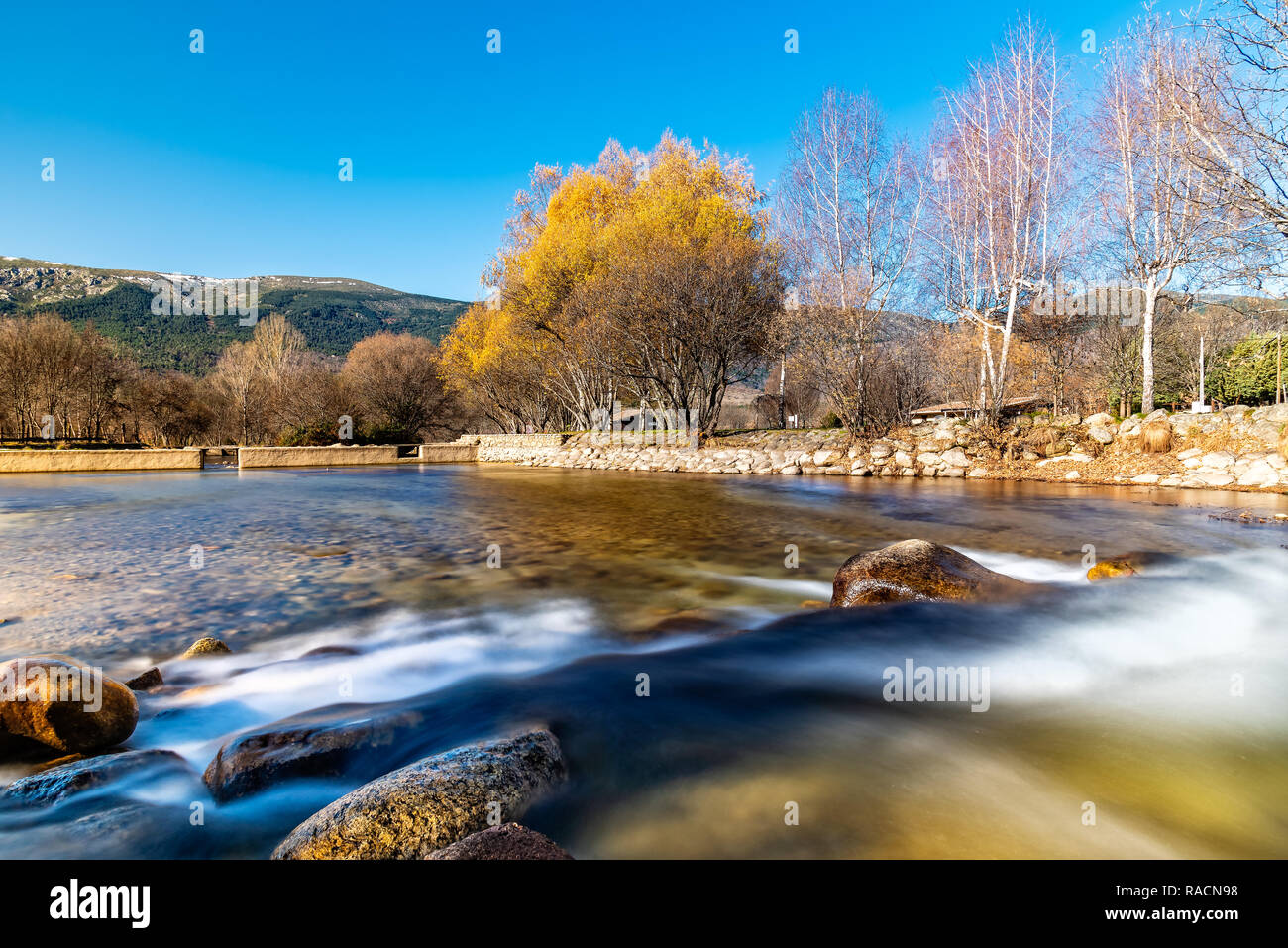 Water flowing over a small dam in Lozoya River near El Paular. Long ...