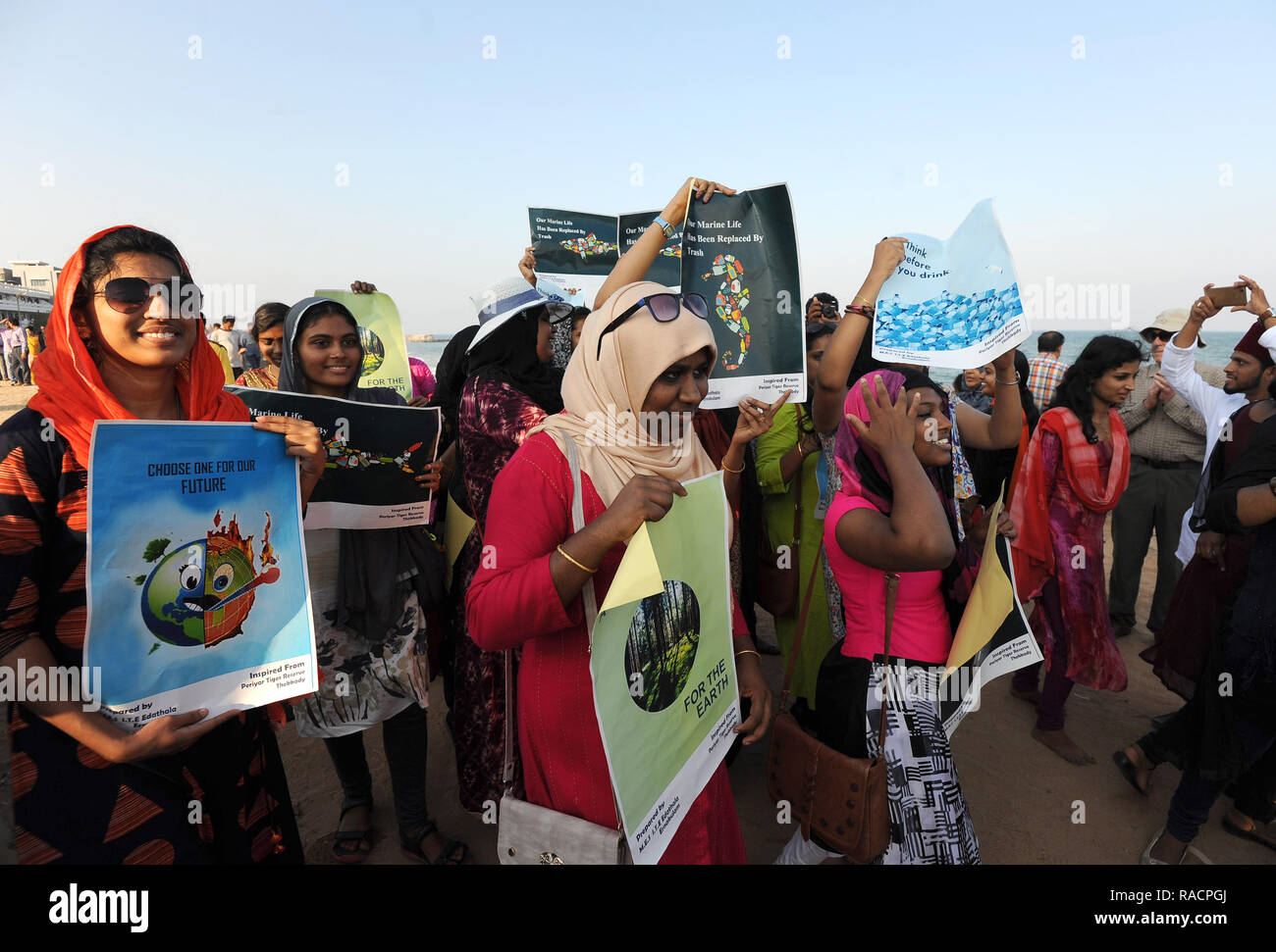 Women holding posters protesting against plastic pollution on the beach ...