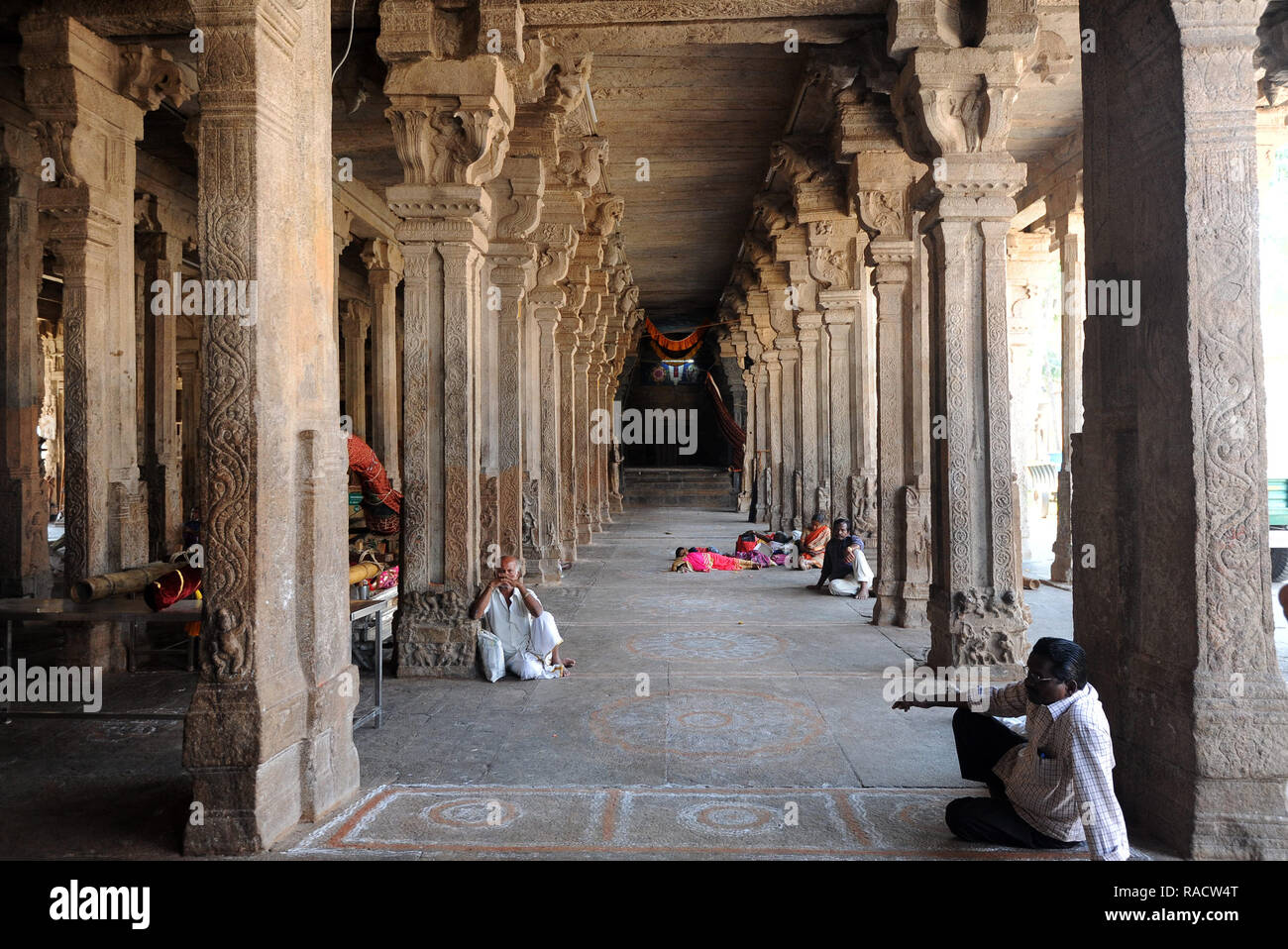 People resting in the stone pillared corridor inside the 11th century ...