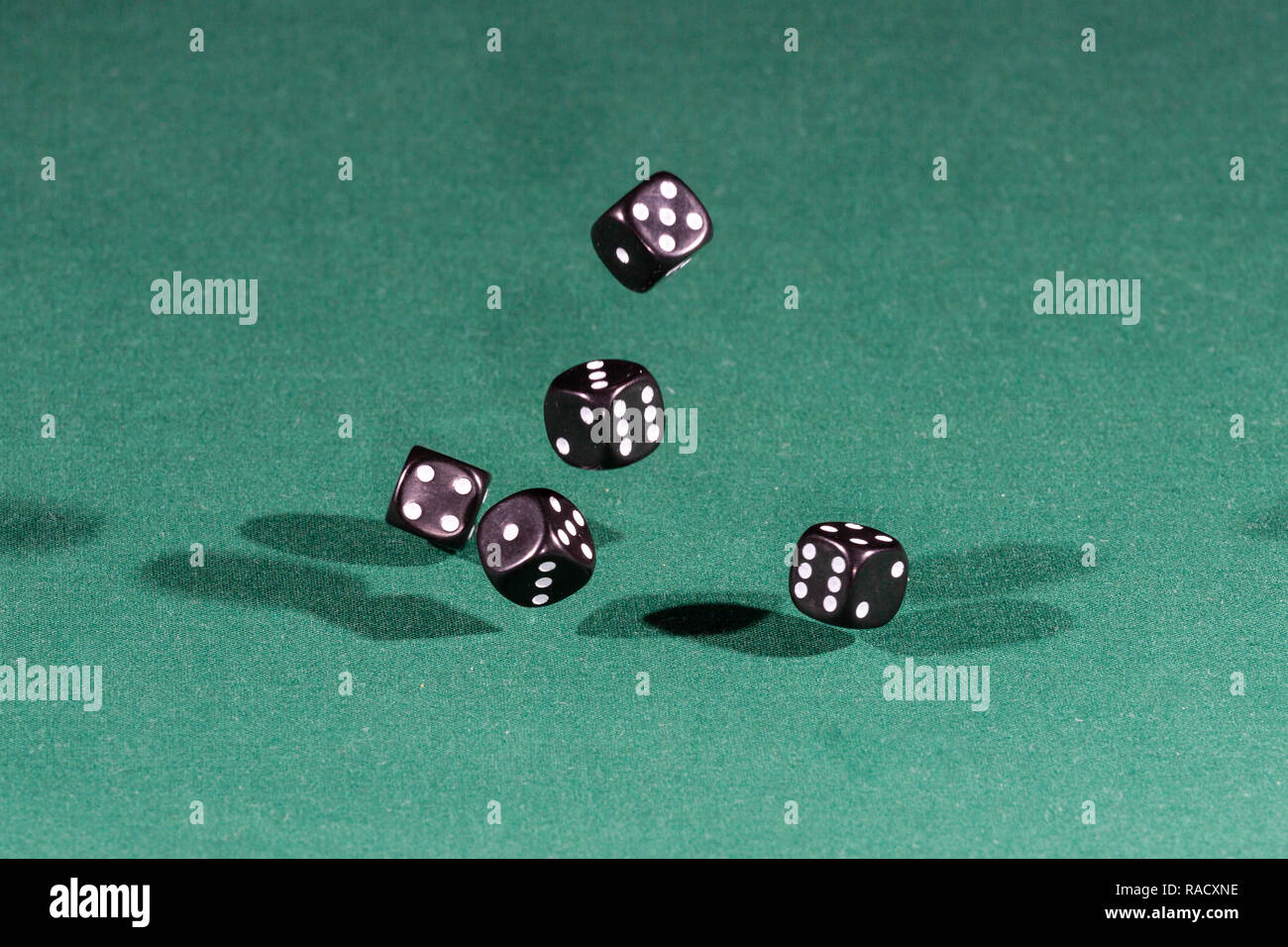 Five black dices falling on a green table Stock Photo - Alamy