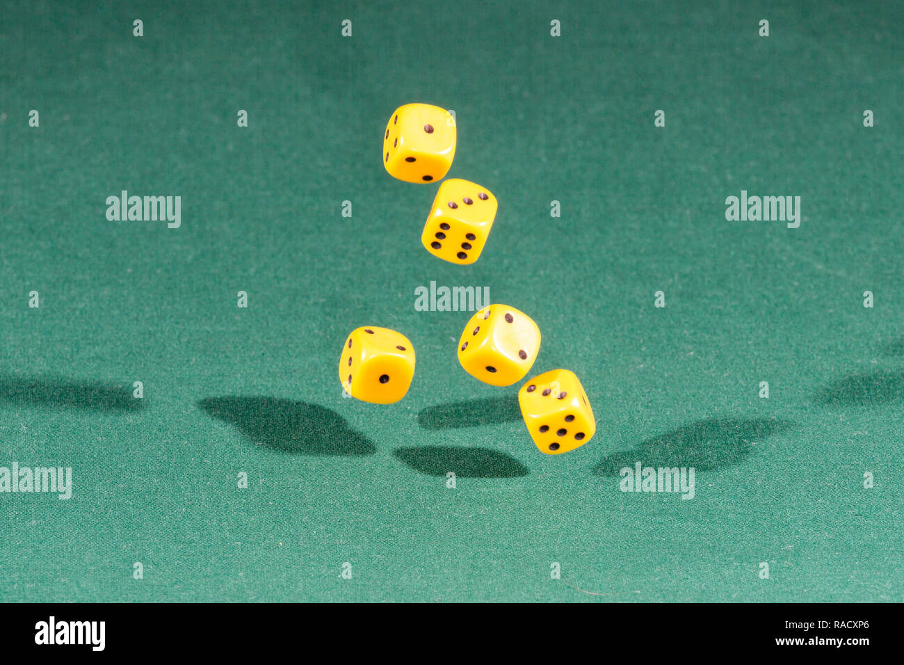 Five yellow dices falling on a green table Stock Photo - Alamy