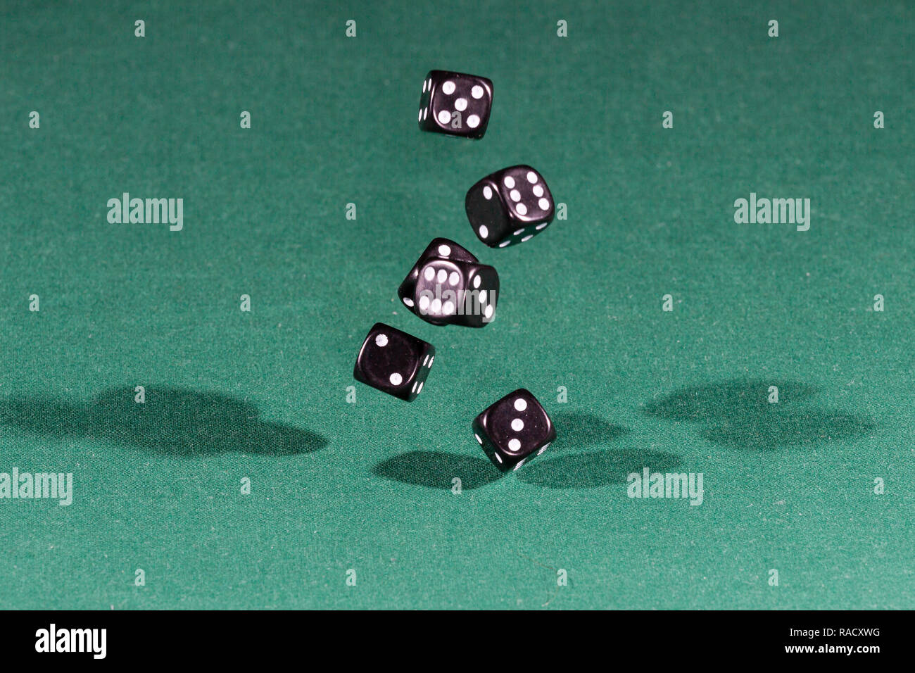 Six black dices falling on a green table Stock Photo - Alamy