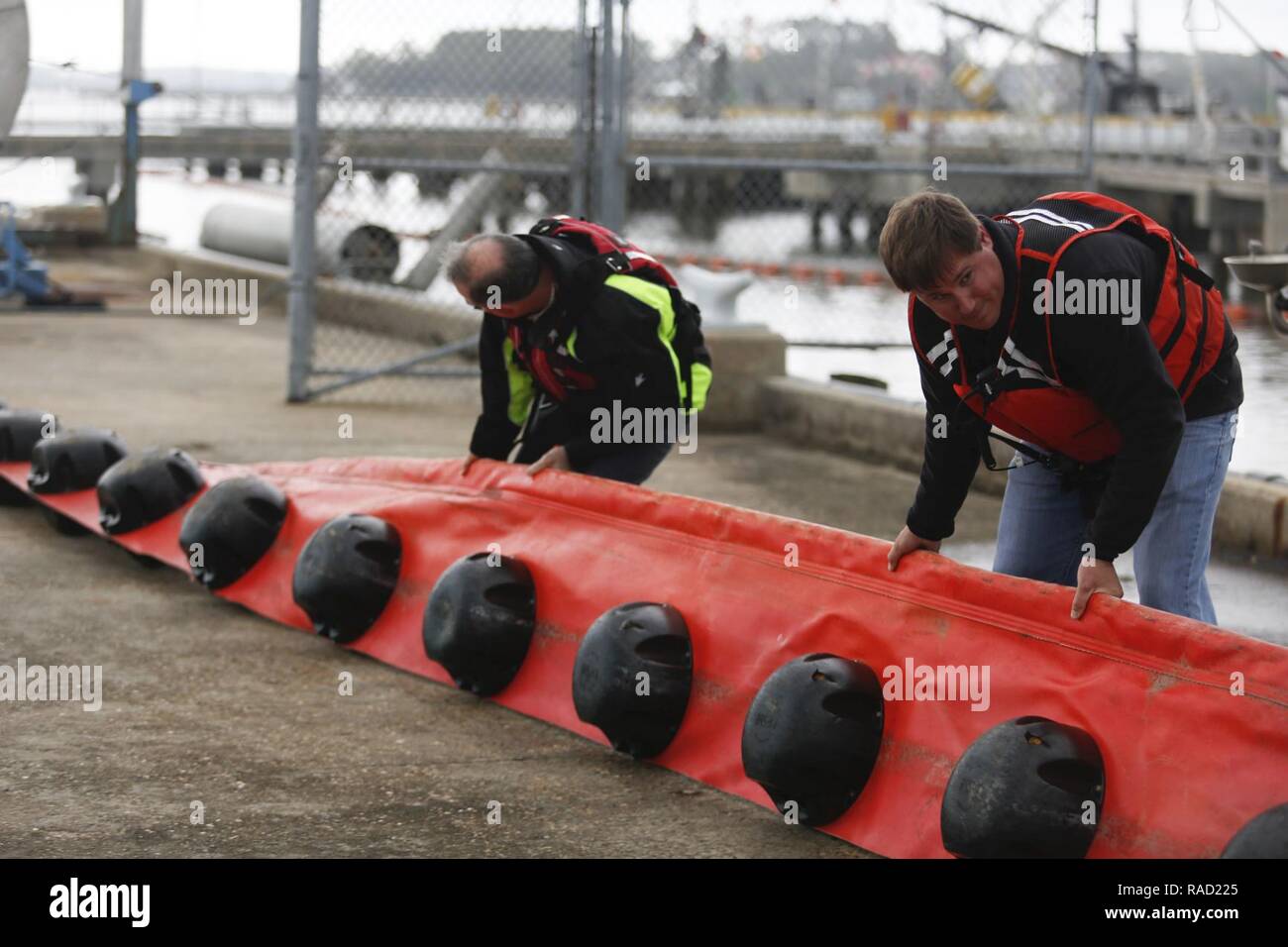 Department of Defense employees help move a boom to protect the shore ...