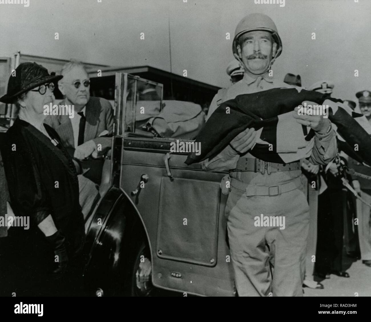 Gunnery Sergeant Carl A. Ostrom, USMC, holds the US Flag prior to the ...