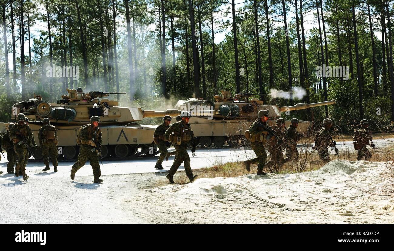 Marines run alongside two M1A1 Abrams tanks as they move to engage ...