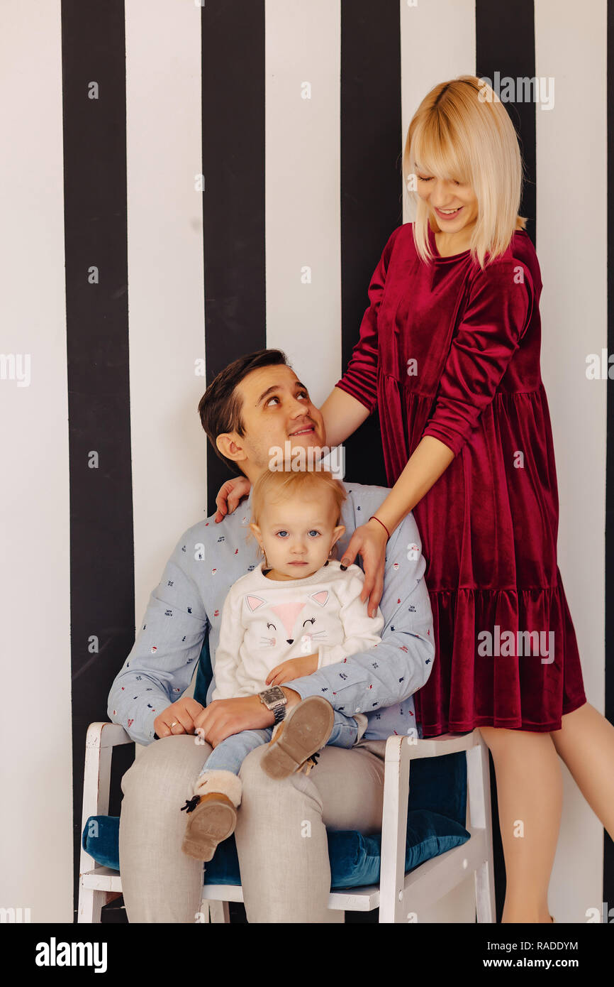 beautiful family with a small daughter, a simple background, happiness ...