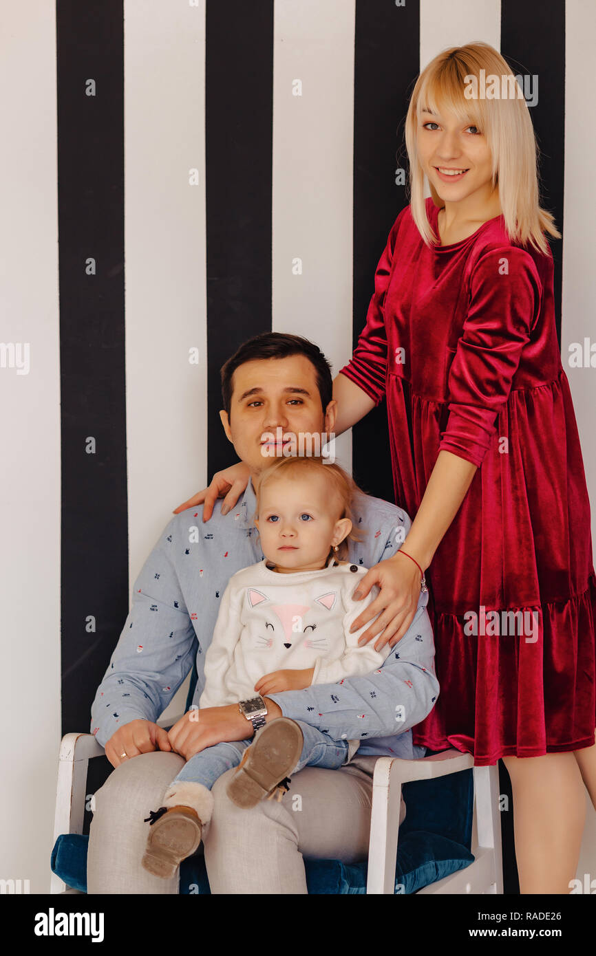 beautiful family with a small daughter, a simple background, happiness ...