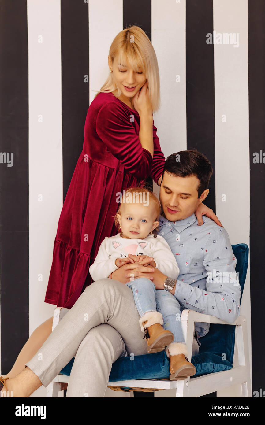 beautiful family with a small daughter, a simple background, happiness ...