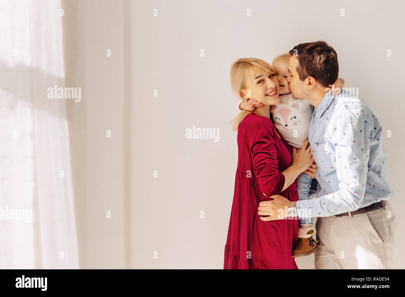 beautiful family with a small daughter, a simple background, happiness ...