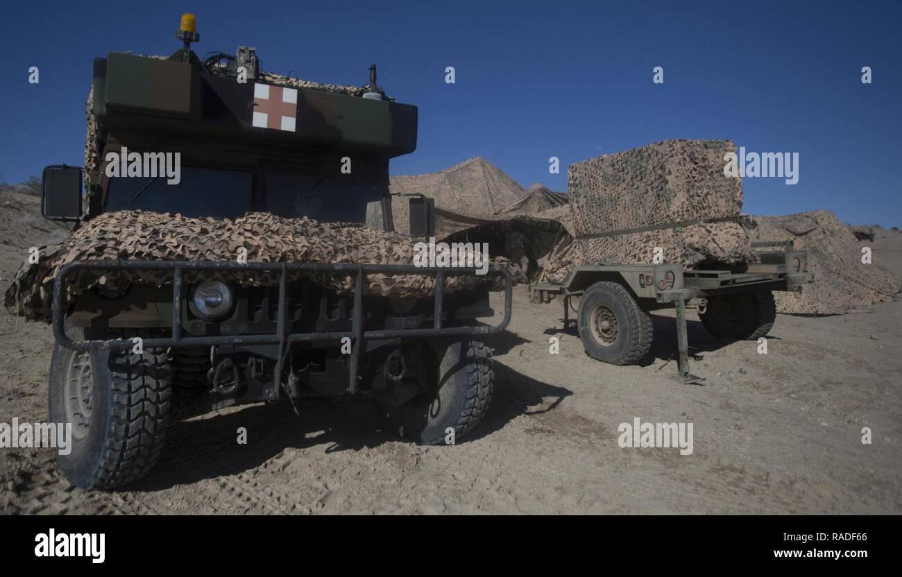 A Humvee and gear are covered in camouflage netting during a Deployment ...