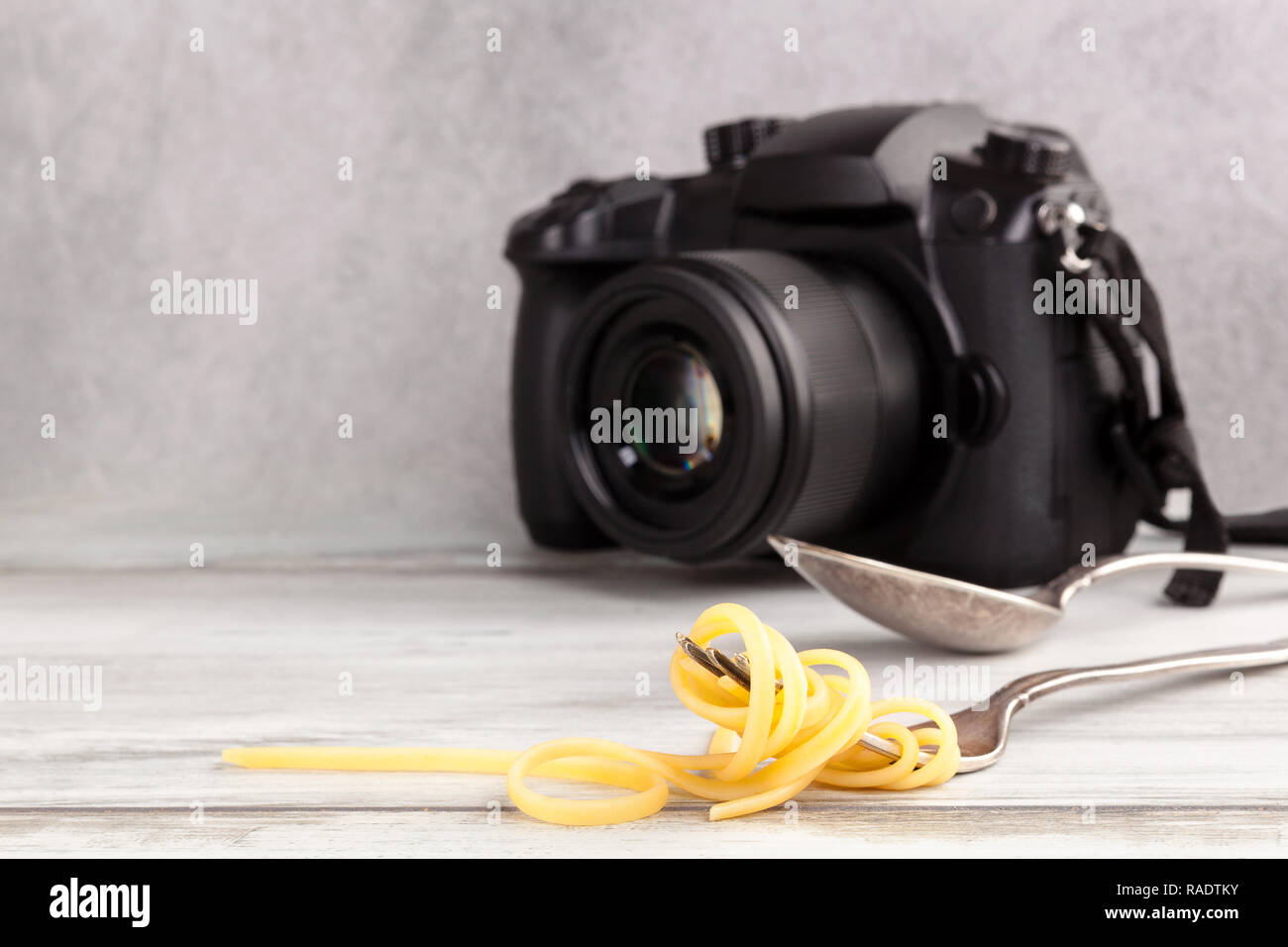 Spaghetti on fork and dslr camera on wooden table. Food photography ...