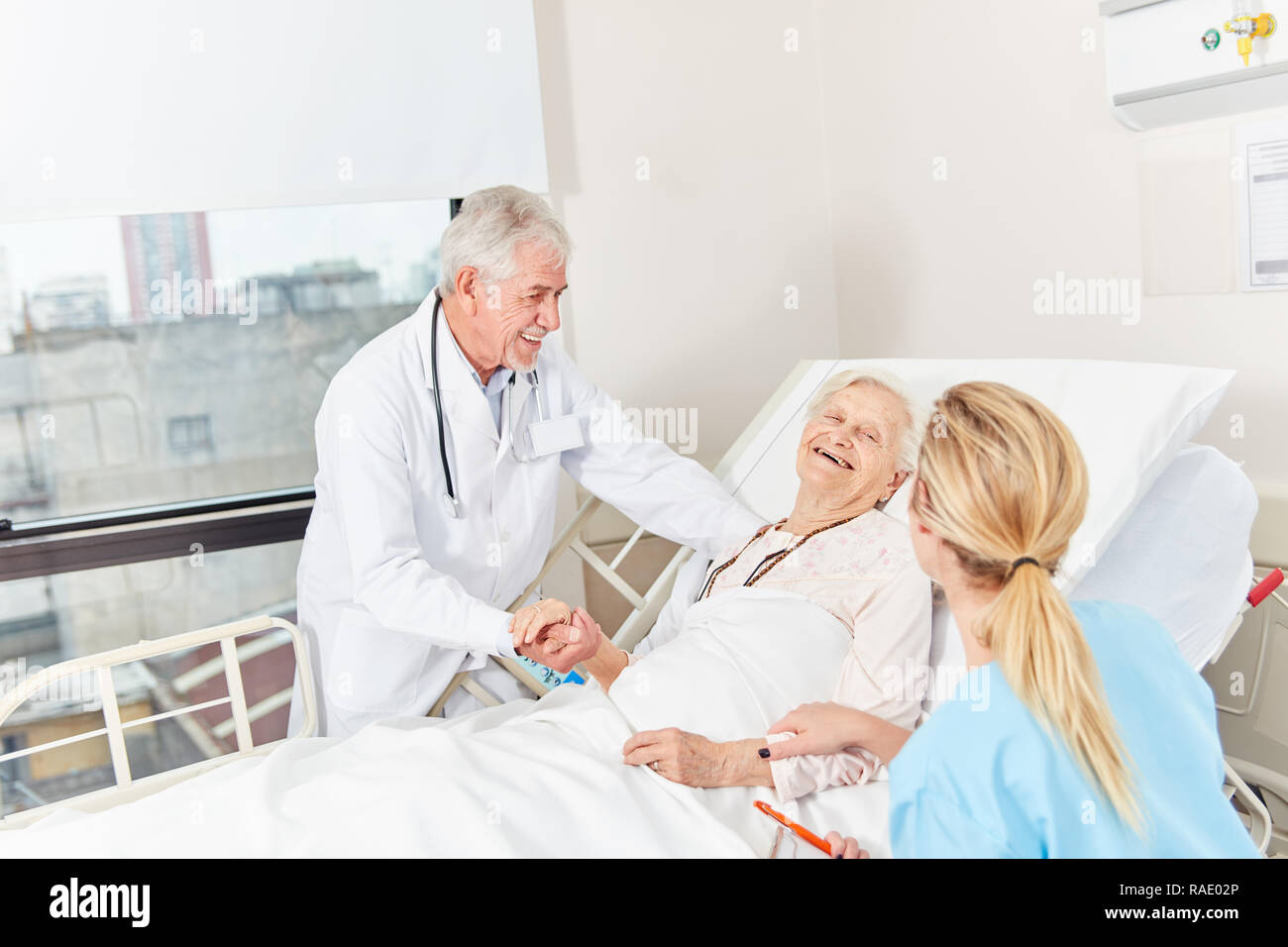 Doctor and nurse at the bedside visit of a senior woman Stock Photo - Alamy