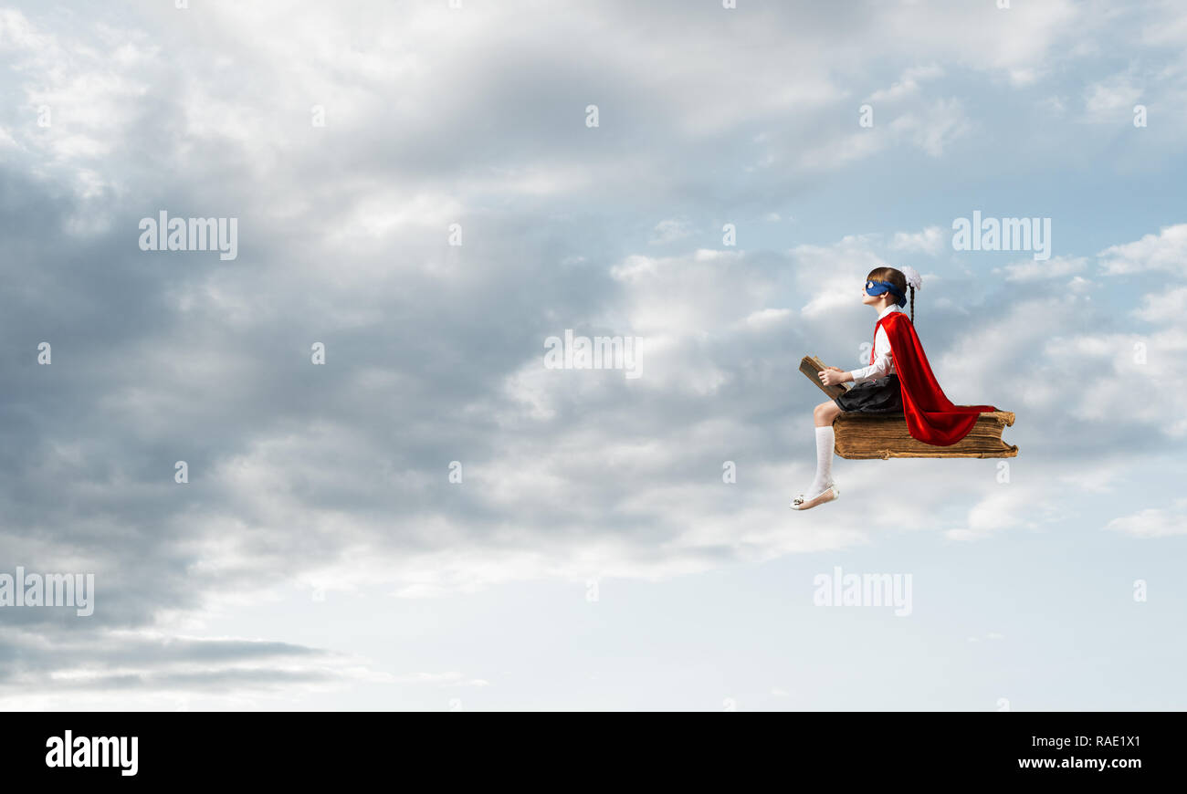 Girl power concept with cute kid guardian against cloudscape background ...