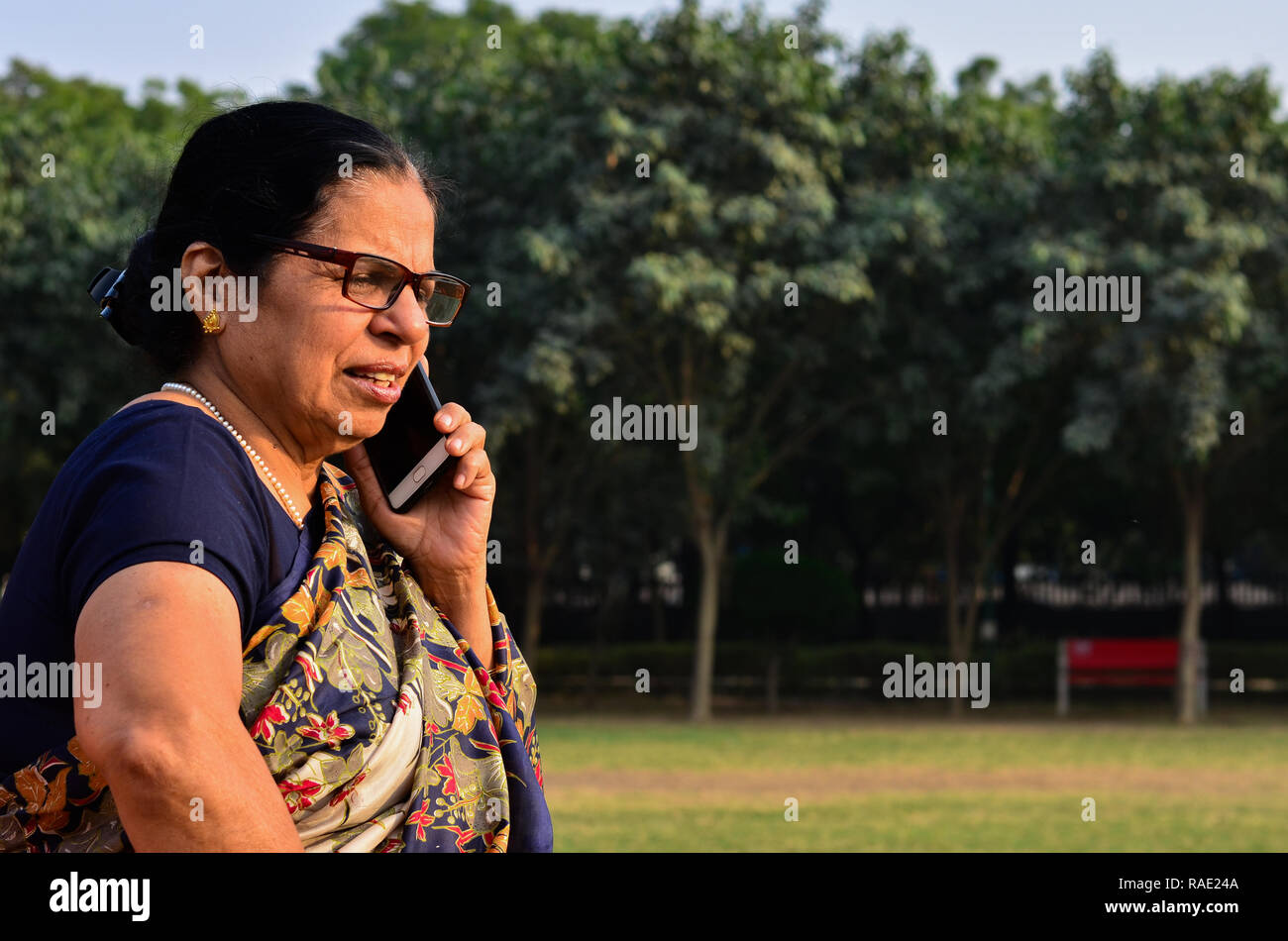Senior Indian woman giving angry expressions while speaking on phone ...