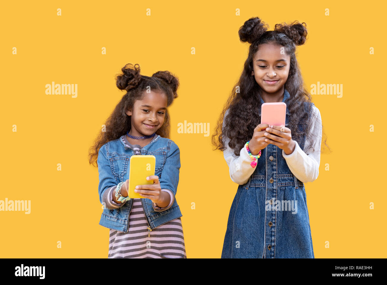 Positive cute girls texting to each other Stock Photo - Alamy