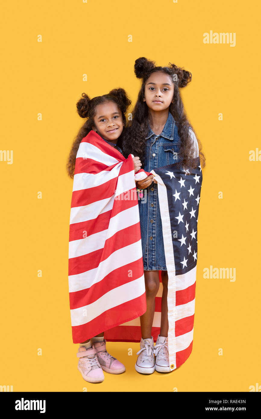 Nice cute sisters being wrapped in the flag Stock Photo - Alamy