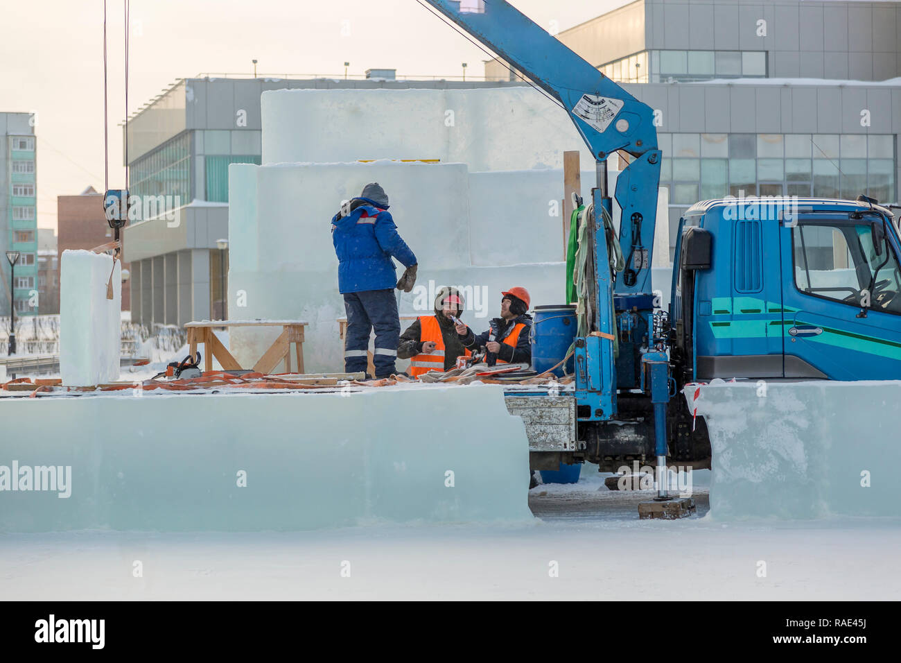 Workers at the construction site of the ice town at the truck crane ...