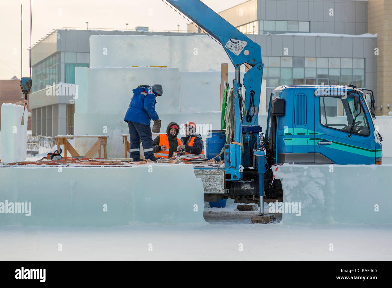 Workers at the construction site of the ice town at the truck crane ...