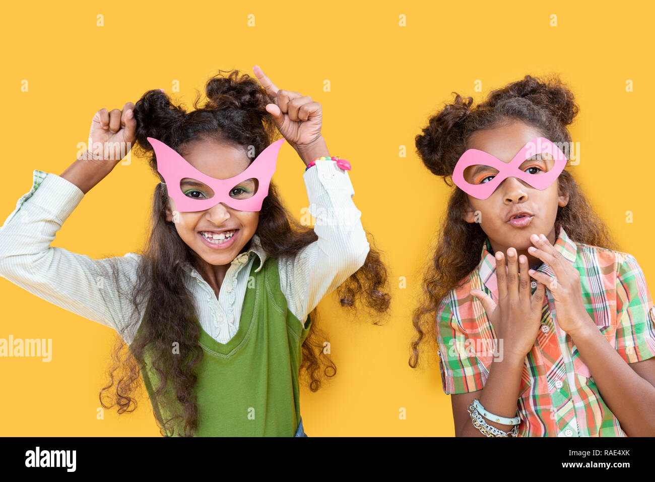 Joyful nice girls wearing pink masks on their face Stock Photo - Alamy